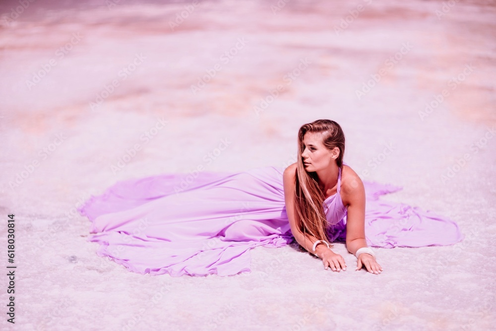Foto de Pink lake woman. A woman in a pink dress sits on the salty ...