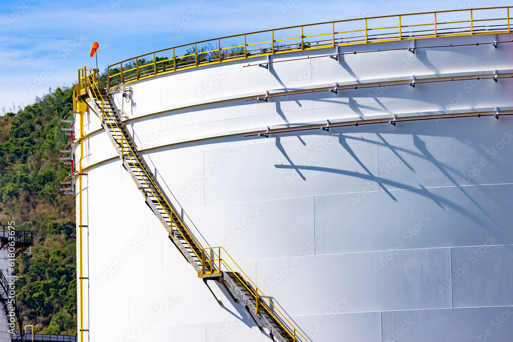 White oil storage fuel tanks at depot station with access ladder ...