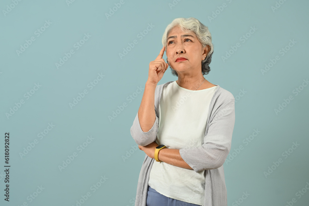 Confused and thoughtful senior woman thinking and looking up expressing ...