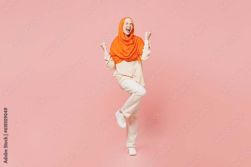 Full body overjoyed young arabian asian muslim woman wear orange abaya ...