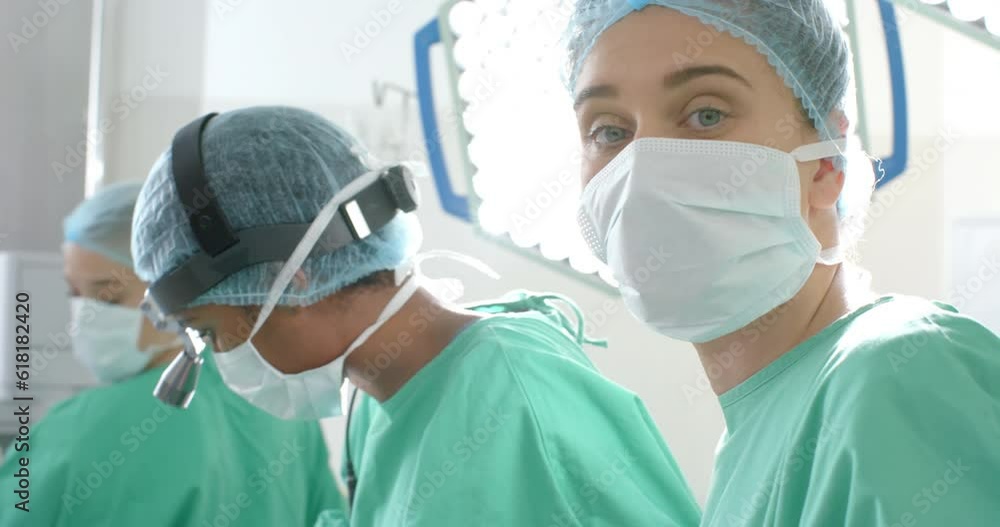 Portrait of caucasian female surgeon wearing face mask in operating ...