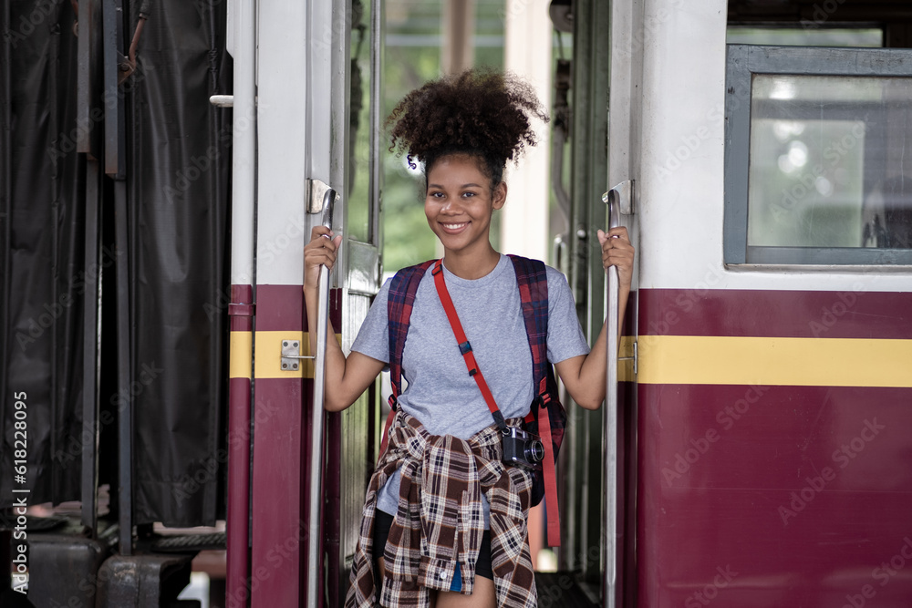 Traveler african asian american woman getting in a train to hop on ...