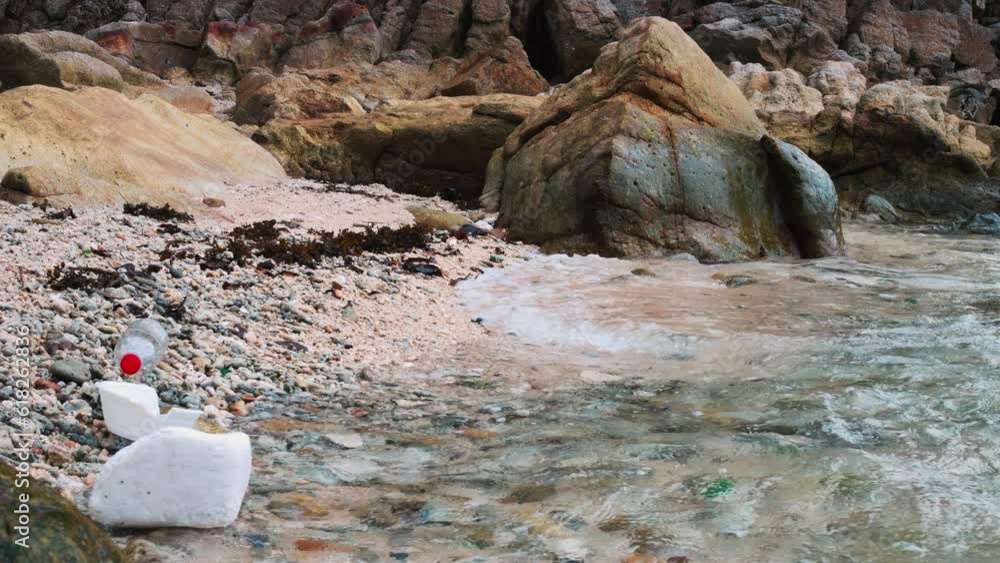 Dirty littered seashore. Waves wash littered seashore. Problem of ...