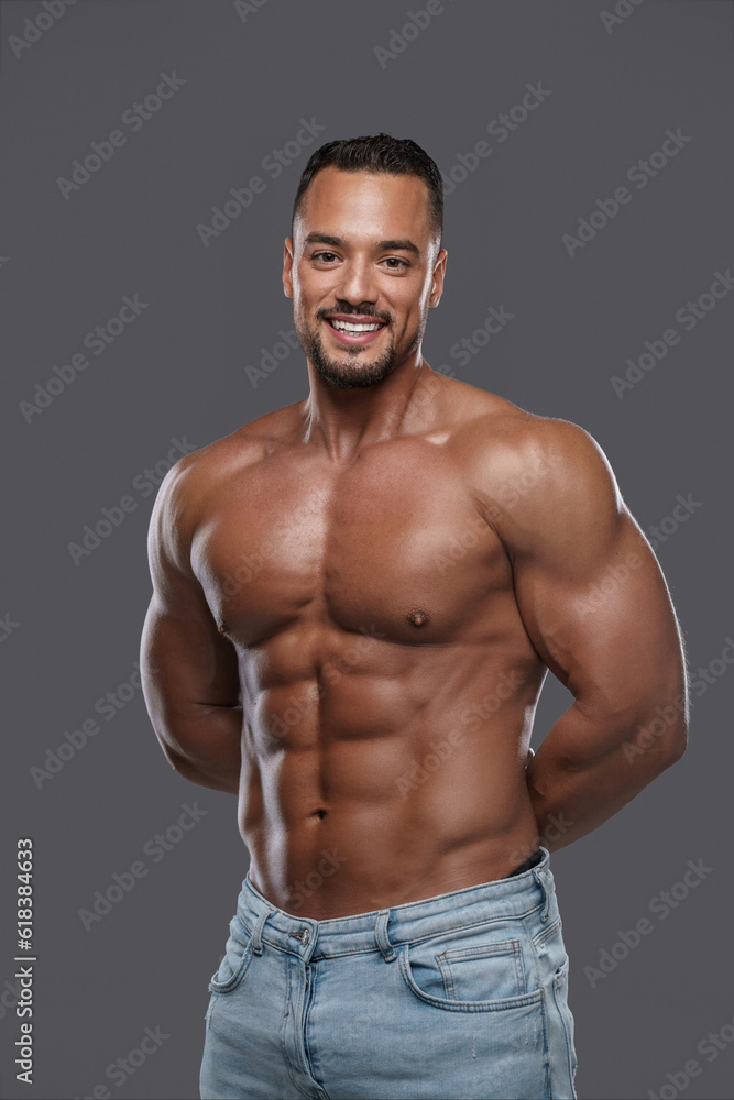 Charming and muscular male model with a dazzling smile poses shirtless ...
