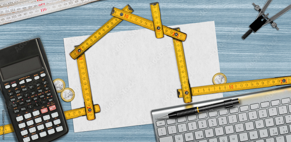 Folding wooden ruler in the shape of a house on a desk with blank sheet ...