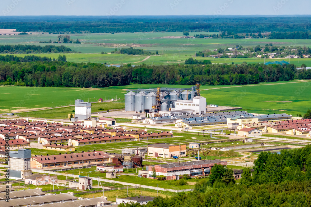 aerial panoramic view over silos and rows of barns, pigsties, chicken ...