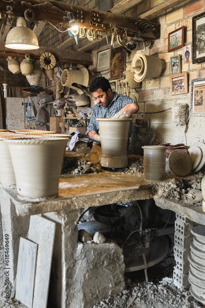 master craftsman making clay pots in ceramic workshop with rotating ...