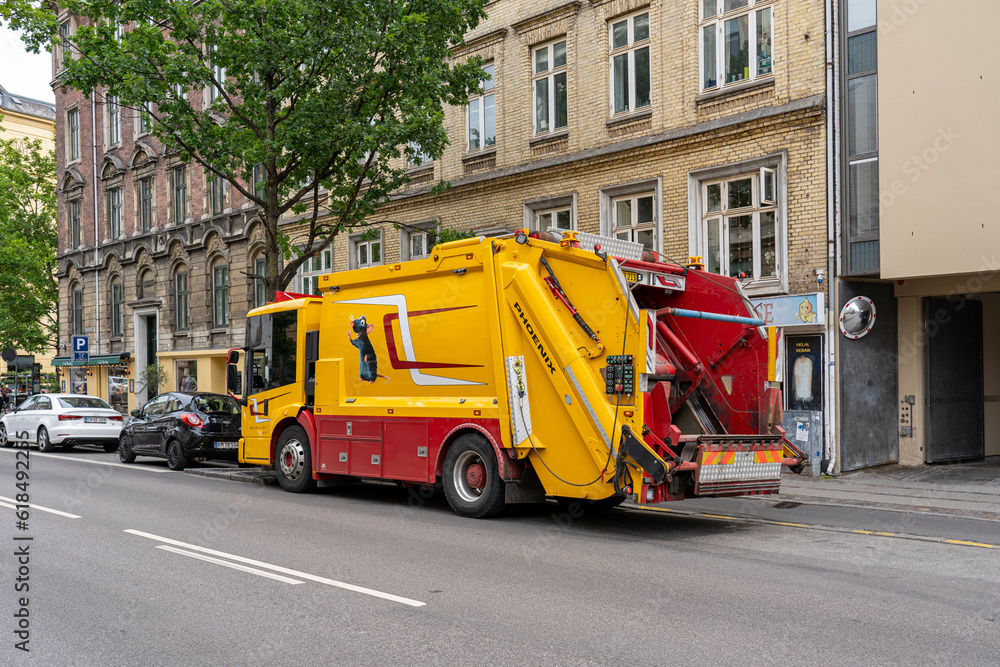 Copenhagen, Denmark - June 30, 2023: A large yellow and red trash truck ...