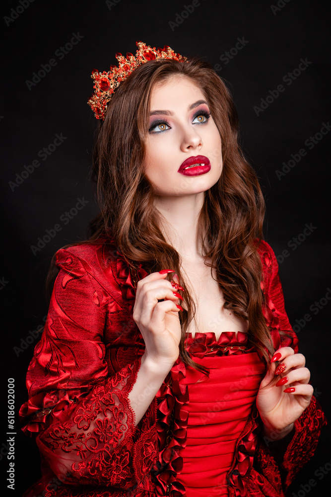 Portrait of a young, attractive vampire woman in a red dress in the ...
