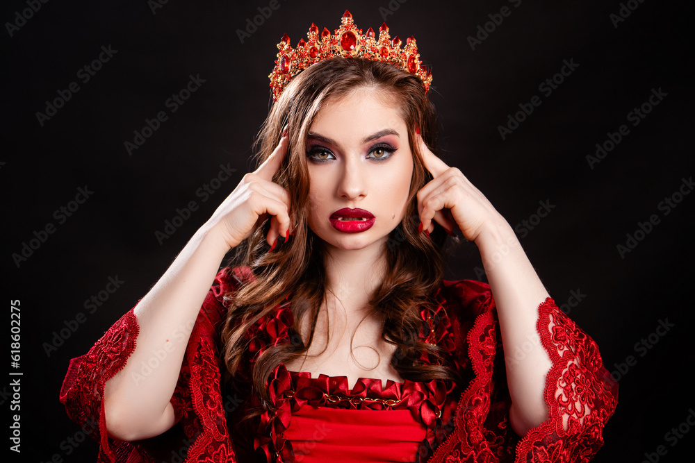 Portrait of a young, attractive vampire woman in a red dress in the ...