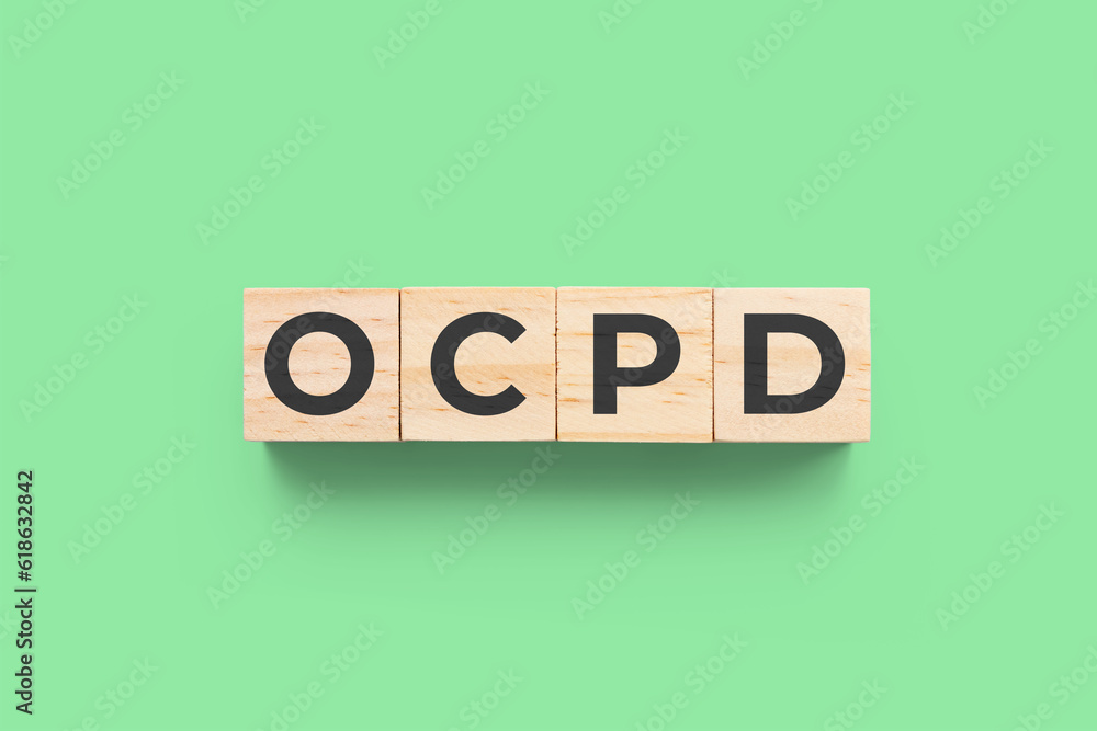 OCPD (Obsessive-Compulsive Personality Disorder) wooden cubes on green ...