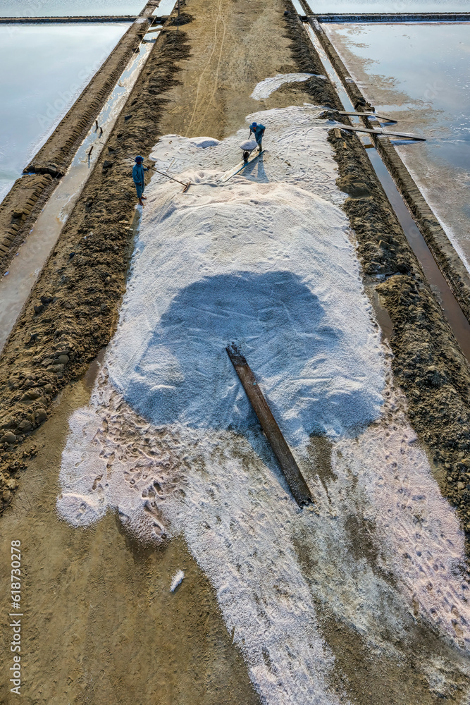 Field and Sea salt pile pyramid ready for harvest in salt farm. Sea ...