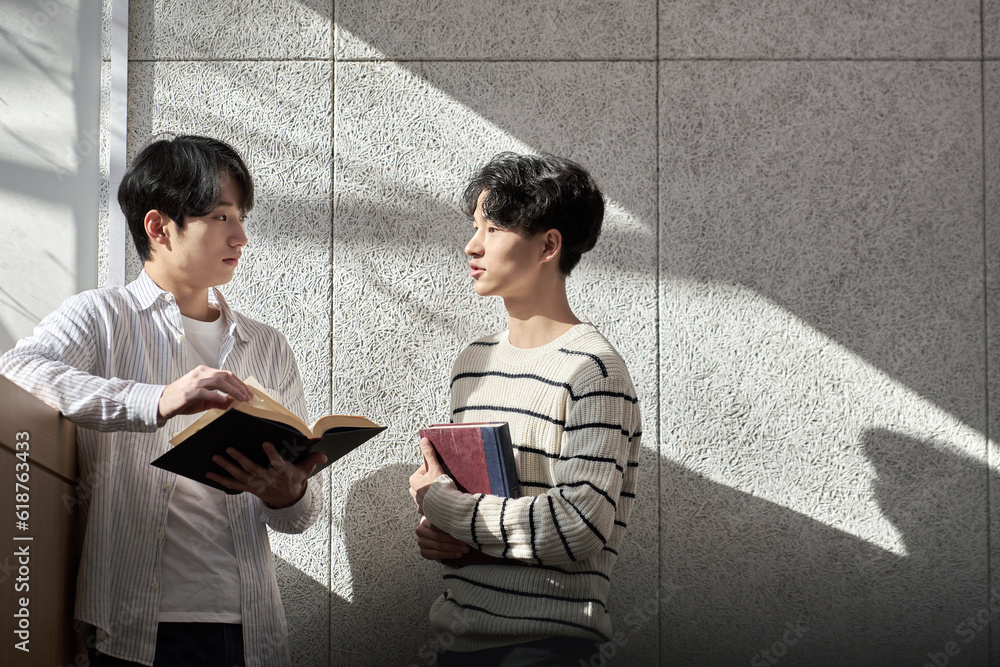 Young male college student models leaning against the wall of a ...
