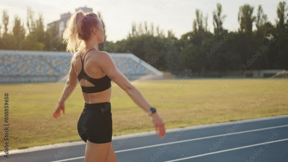 Blonde, walking on a running track in stadium, performing breathing ...