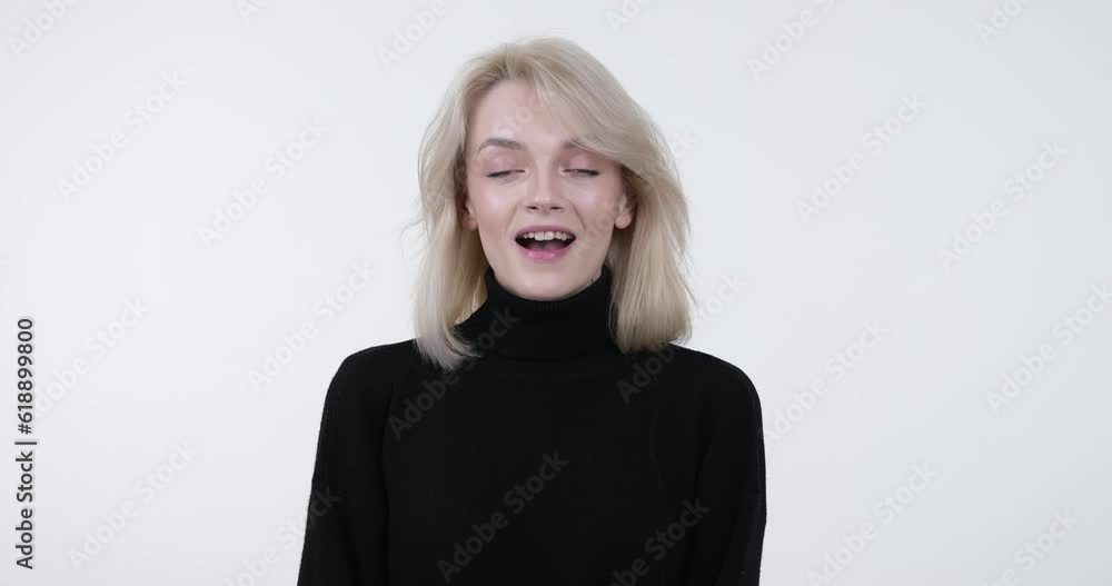A stunning Caucasian woman standing against a pristine white background ...