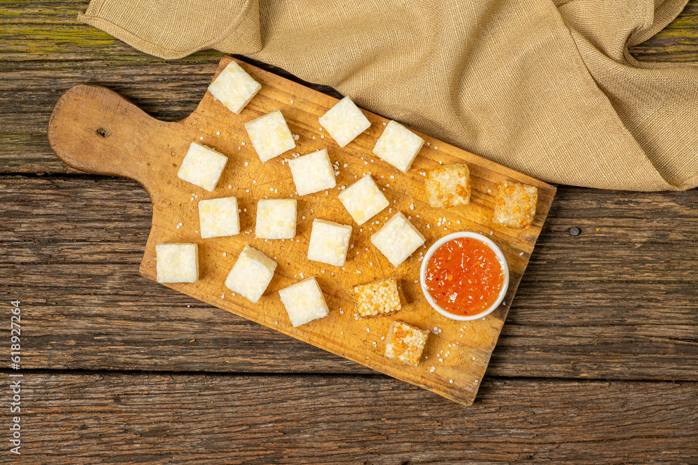 Raw and fried tapioca cubes (Dadinhos de Tapioca) on top of rustic ...