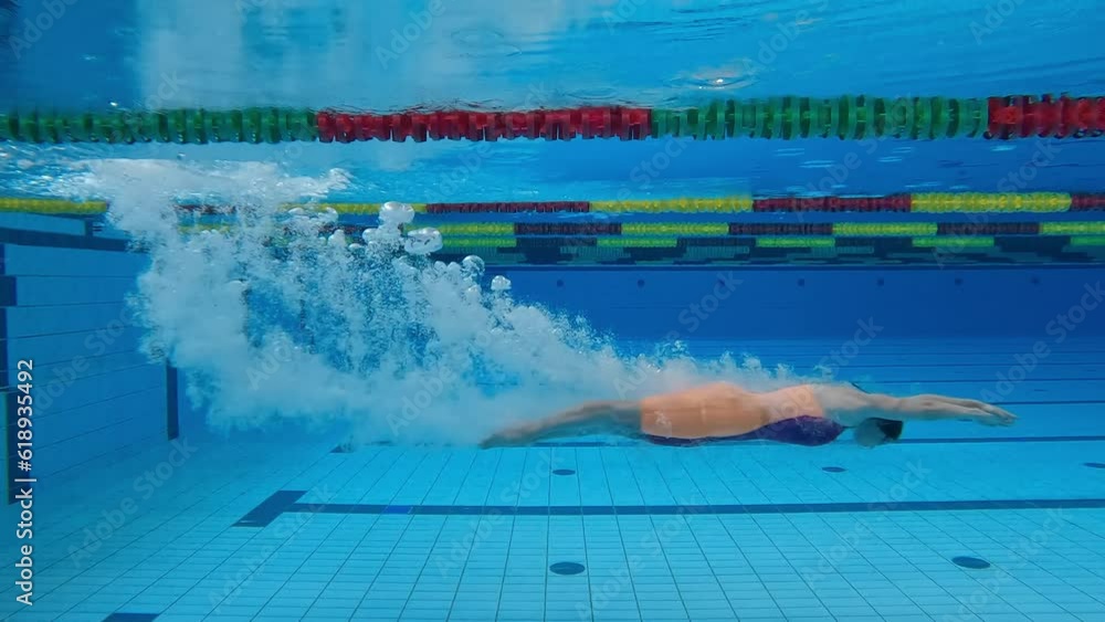 Female swimmer in the water immersion phase, sliding below the water ...