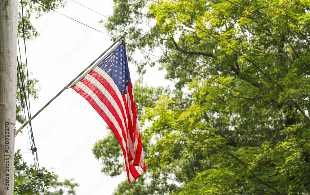 US flag waves proudly in front of an American home, representing the ...
