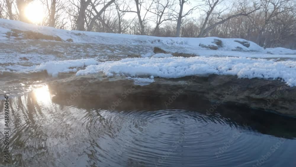 Morning winter sunlight shines on calm lake water. Hot spring water ...