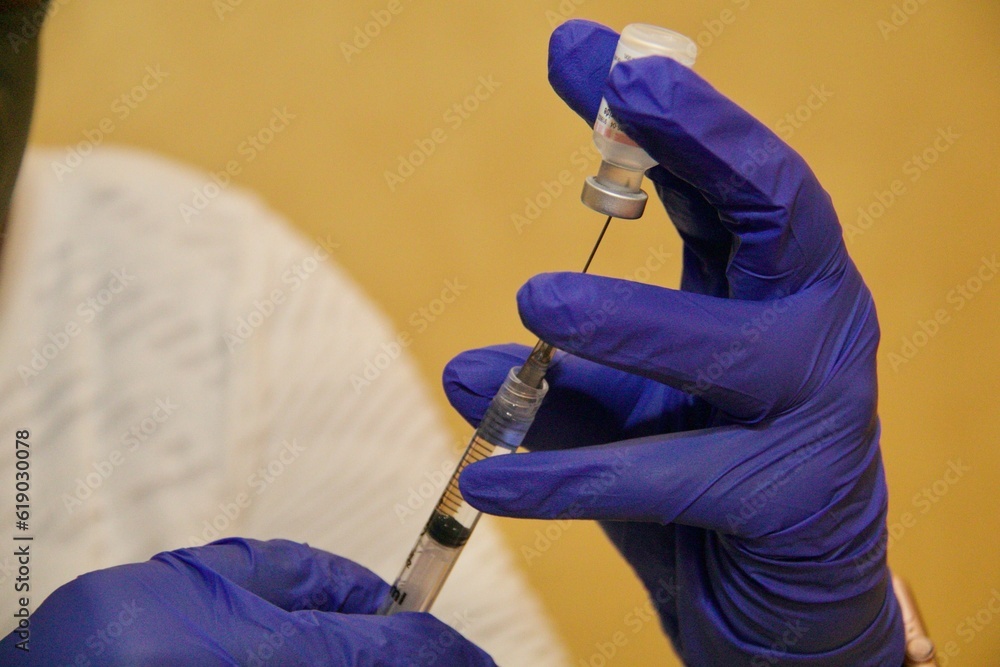 Doctor injecting with hypodermic needle Stock Photo | Adobe Stock