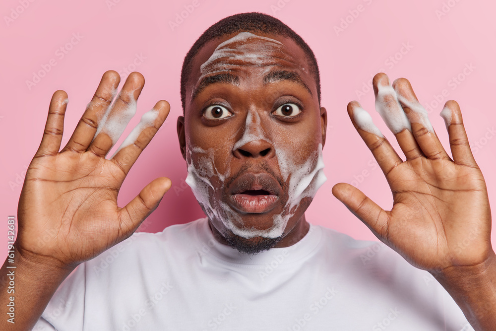 Shocked dark skinned man showcases his dedication to skin care keeps ...