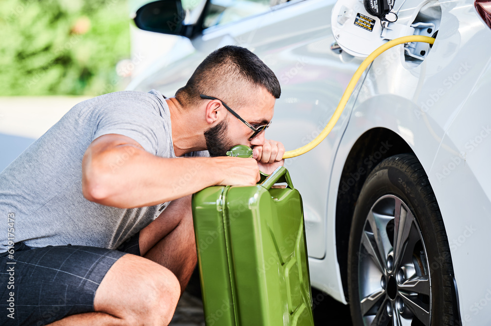 Weird man pumping gasoline from a gas tank into canister. Self ...