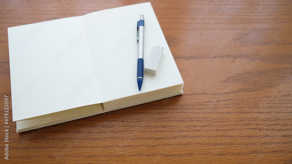 Libreta, lapicero y goma sobre mesa. Stock Photo | Adobe Stock