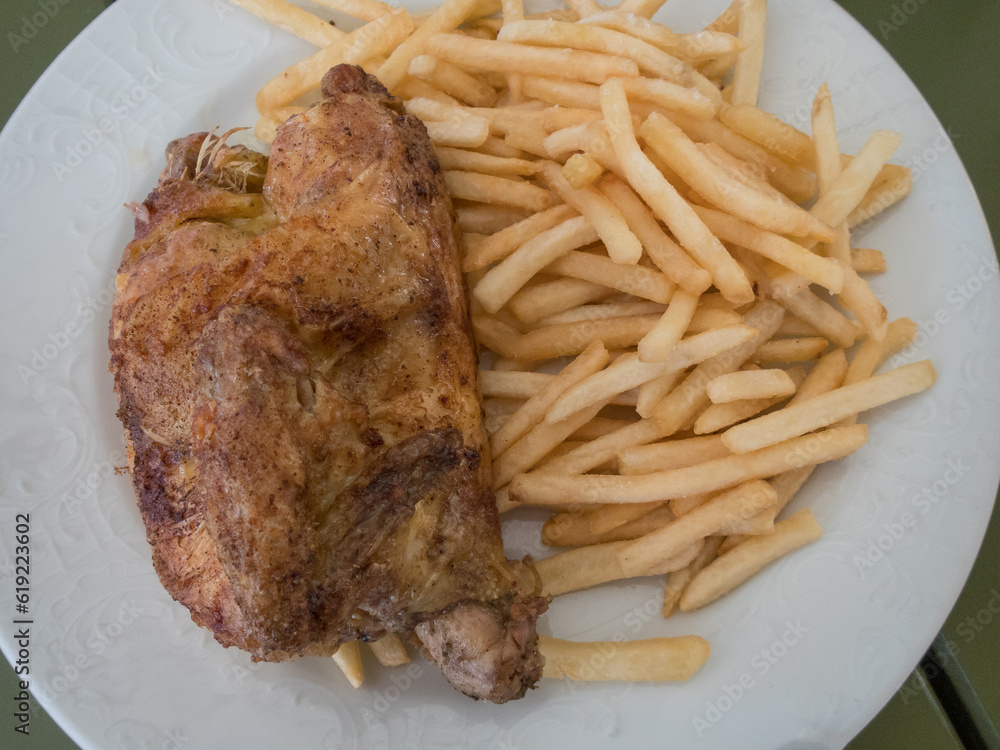 Medio pollo al grill con patatas fritas Stock Photo | Adobe Stock