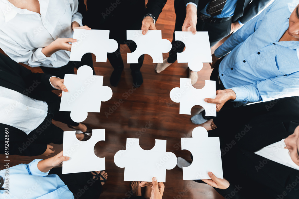 Top view multiethnic business people holding jigsaw pieces and merge ...
