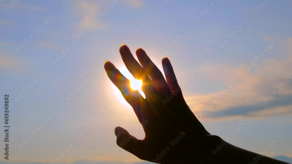 Woman silhouette is waving her hand against the sunset, sunrise sky ...