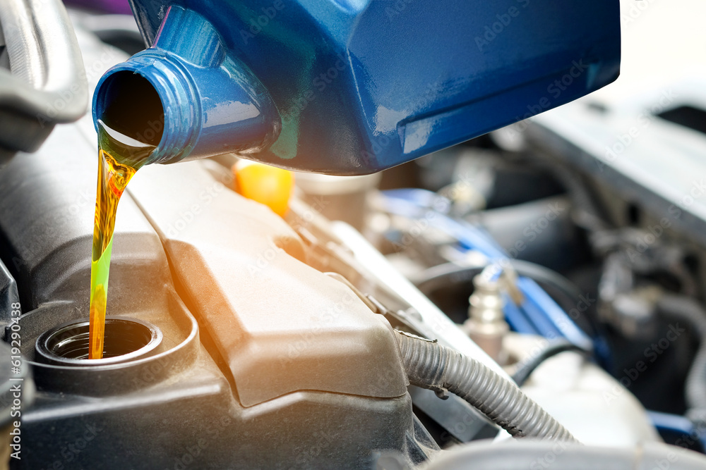 Refueling and pouring oil quality into the engine motor car ...