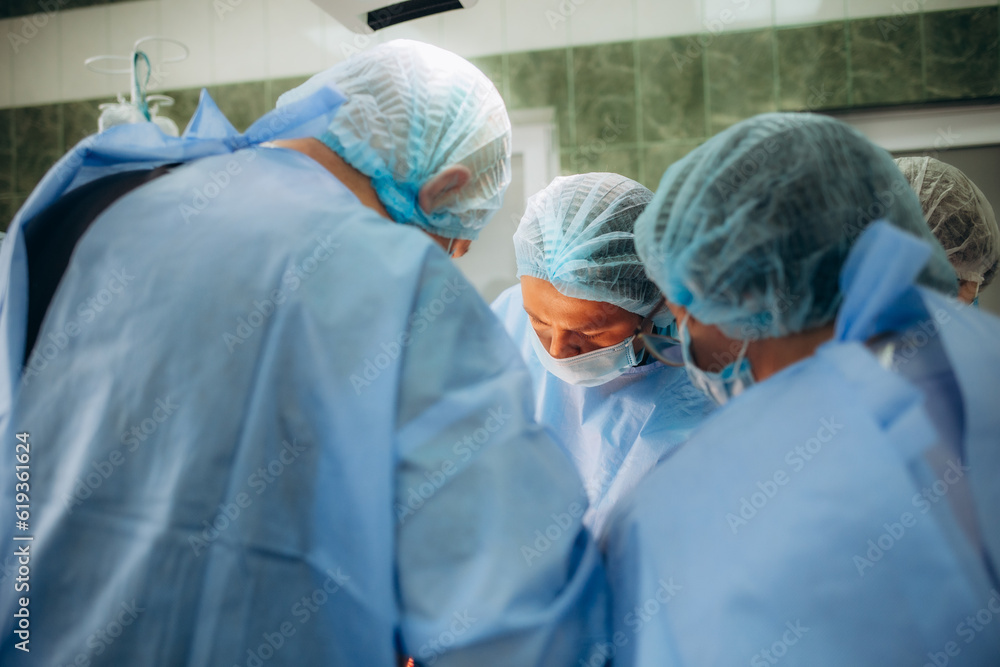 surgeons perfoming surgery operation of abdominal cesarean section ...