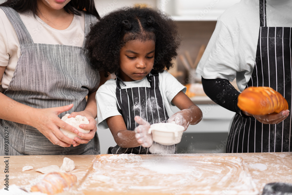 Happy African American kid girl with family cooking break or bakery at ...