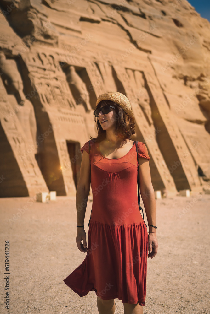 A young girl in red dress visiting the Egyptian Temple of Nefertari ...