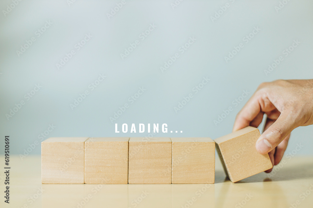 Hand putting wood cube for loading the progress bar. Hand putting wood ...