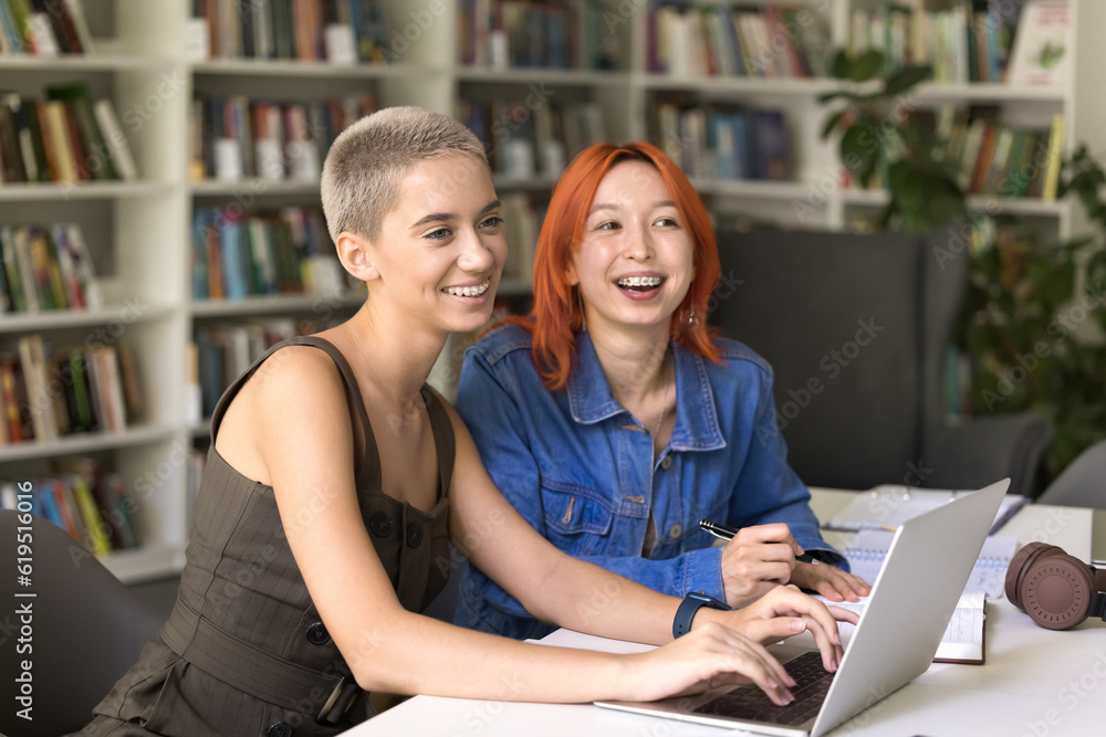 Cheerful college girl friends with teeth brackets working on class ...