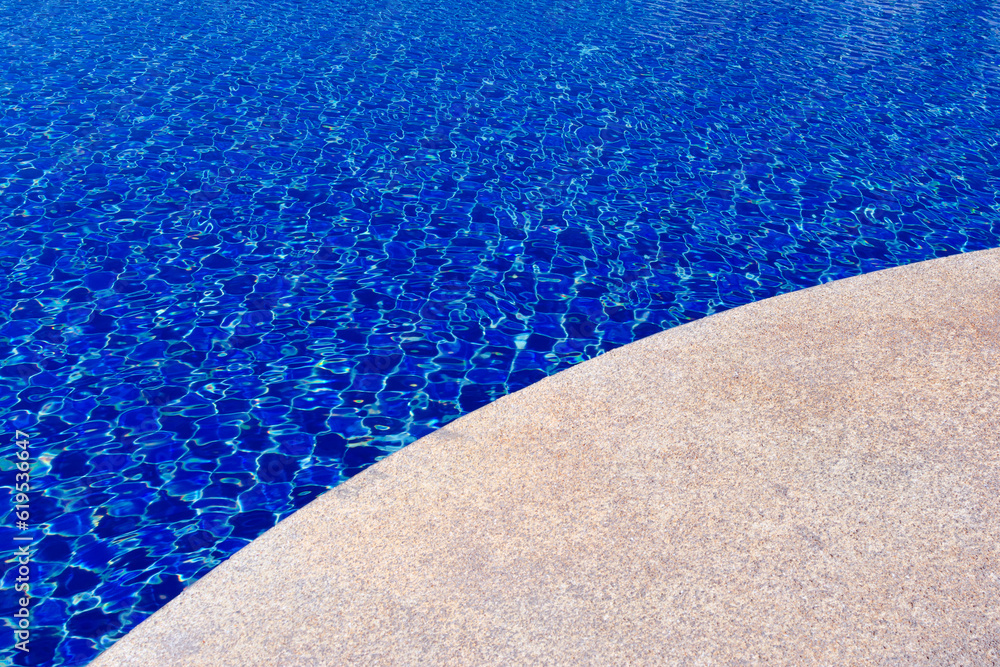 The blue tiles floor under the clear water in the swimming pool ...