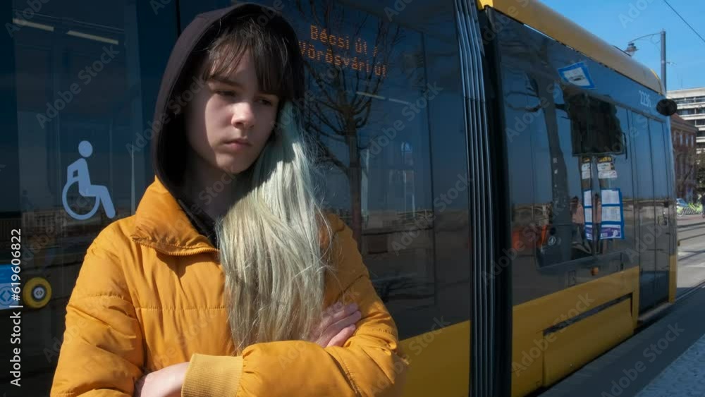 Bus stop with depressed girl. A view of sad teen waiting for somebody ...