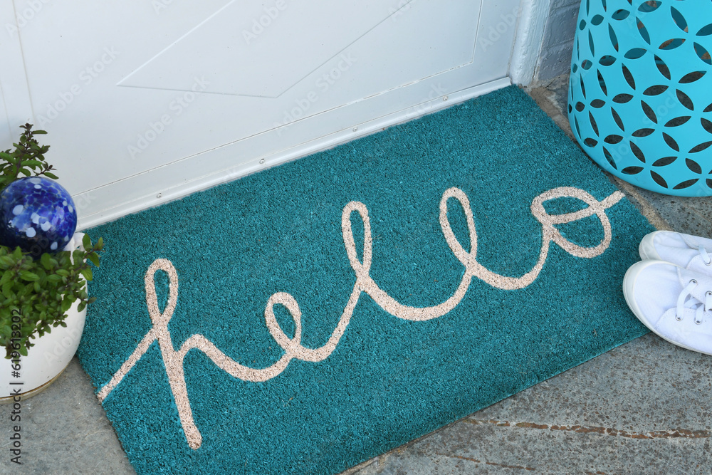 Aqua teal hello welcome mat on a front porch in the summer Stock Photo ...