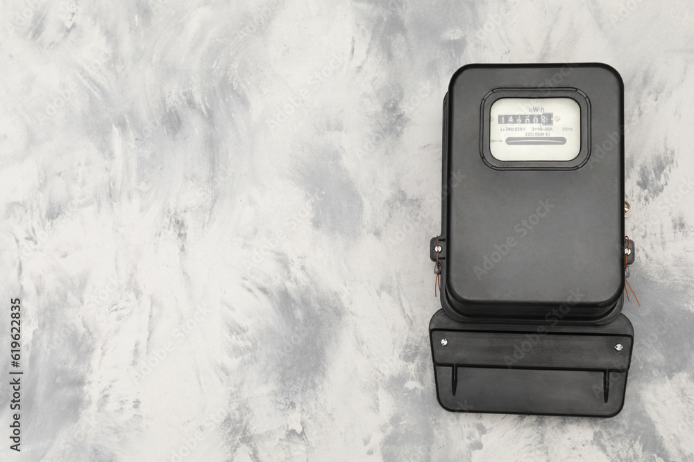 Black electric meter on textured background, top view with space for ...