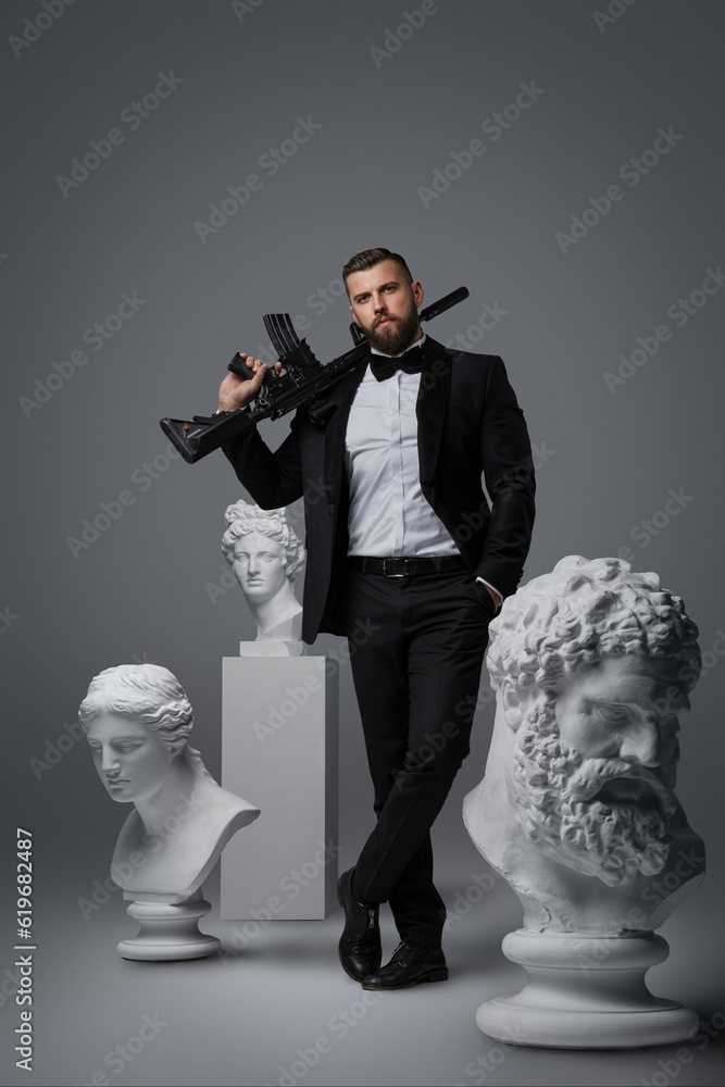 Stylish man with a well-groomed beard dressed in a luxurious black suit ...