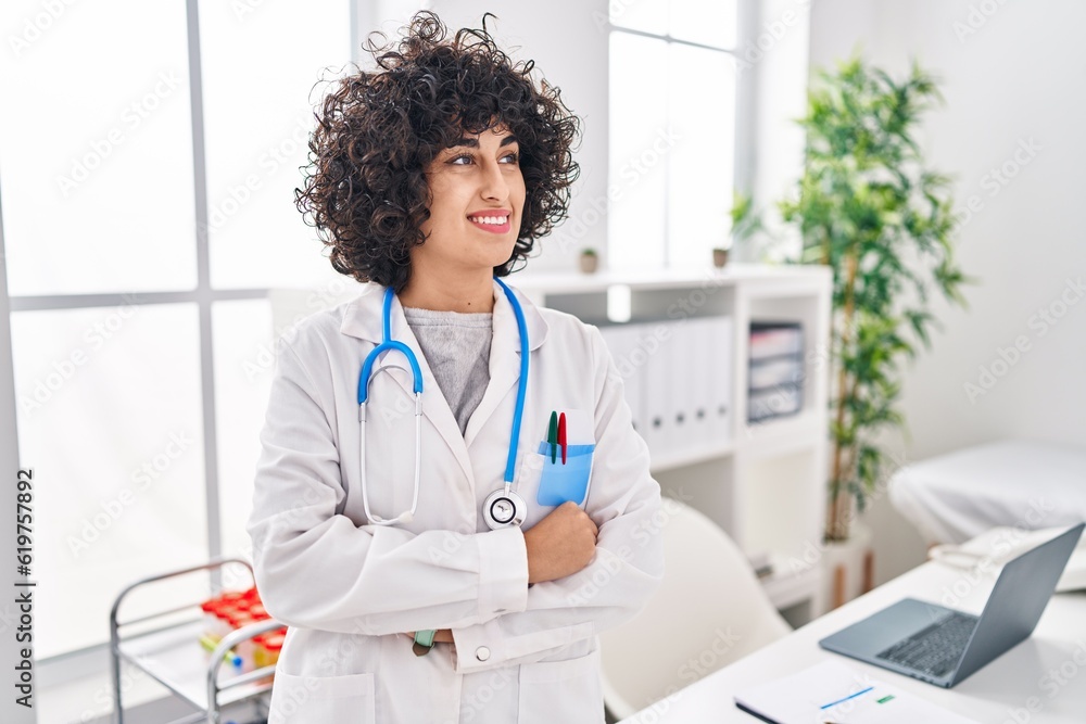 Young middle east woman wearing doctor uniform standing with arms ...