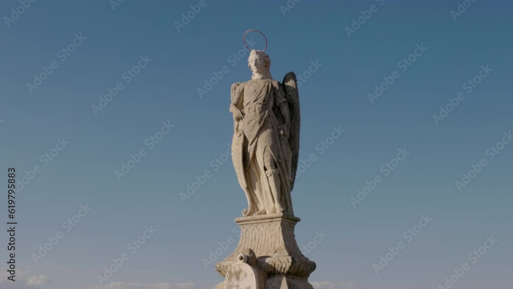 a close tilt up shot of the 17th century statue of the archangel ...