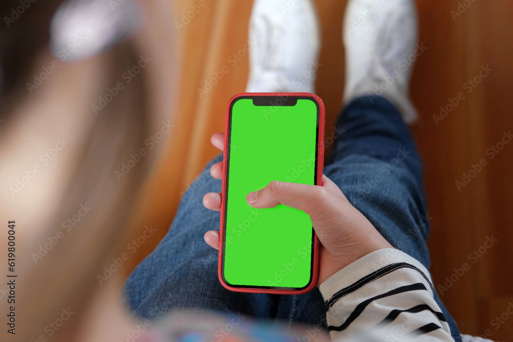 Teenage girl of 12 years with backpack holds a mobile phone green ...