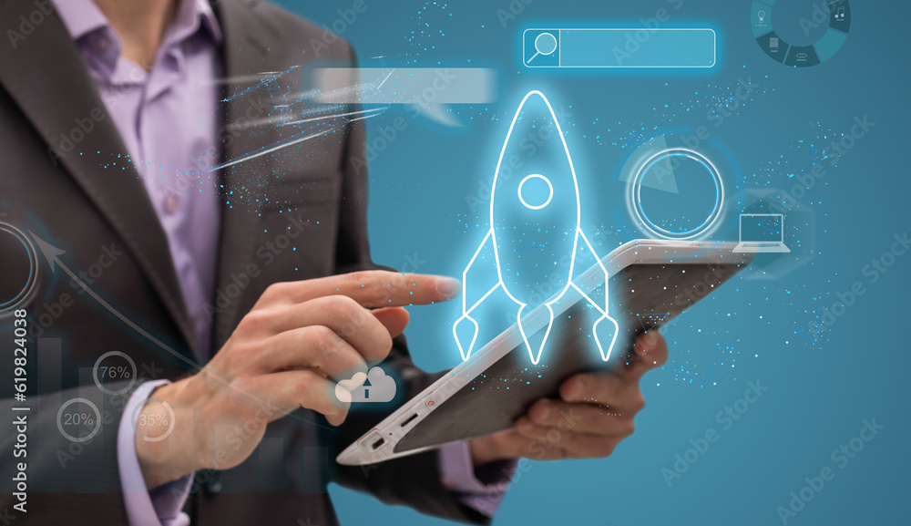 Hand of businessman with tablet launching startup rocket over blurred ...