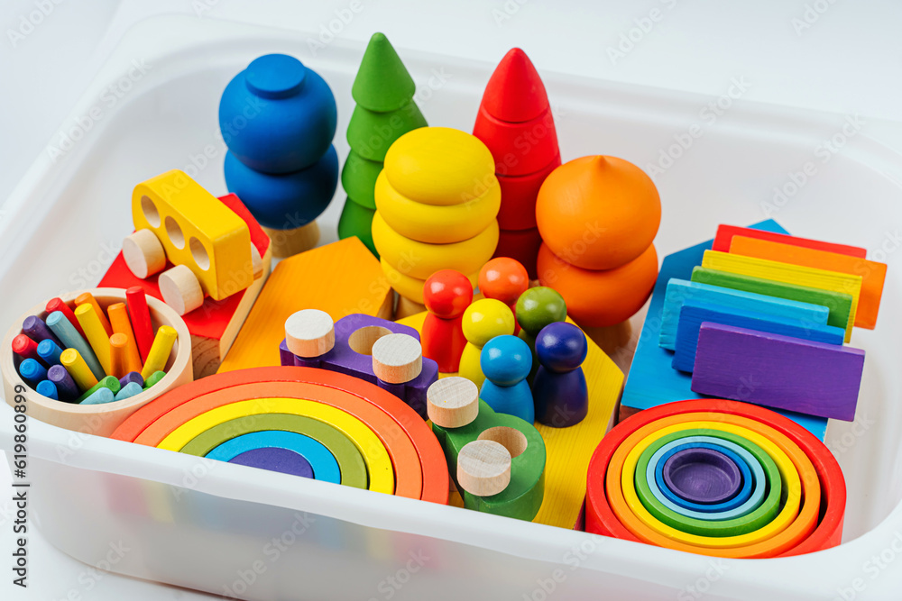 Colorful wooden toys in the colors of the rainbow in plastic box ...