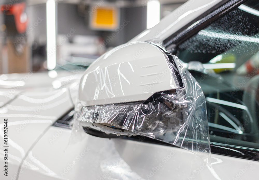 The process of installing PPF on the side of the car. PPF is a ...