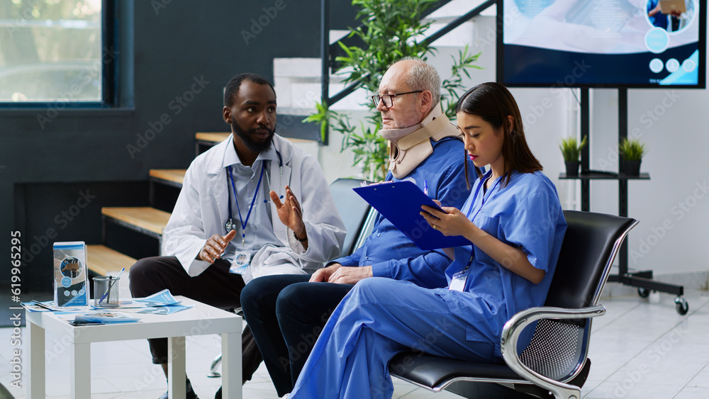 Hospital staff consulting patient with cervical neck collar in hopsital ...