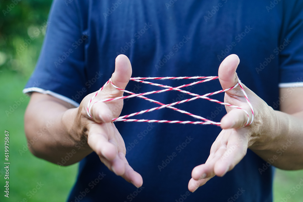 Foto de Closeup man hands is playing rope which called cats cradle game ...