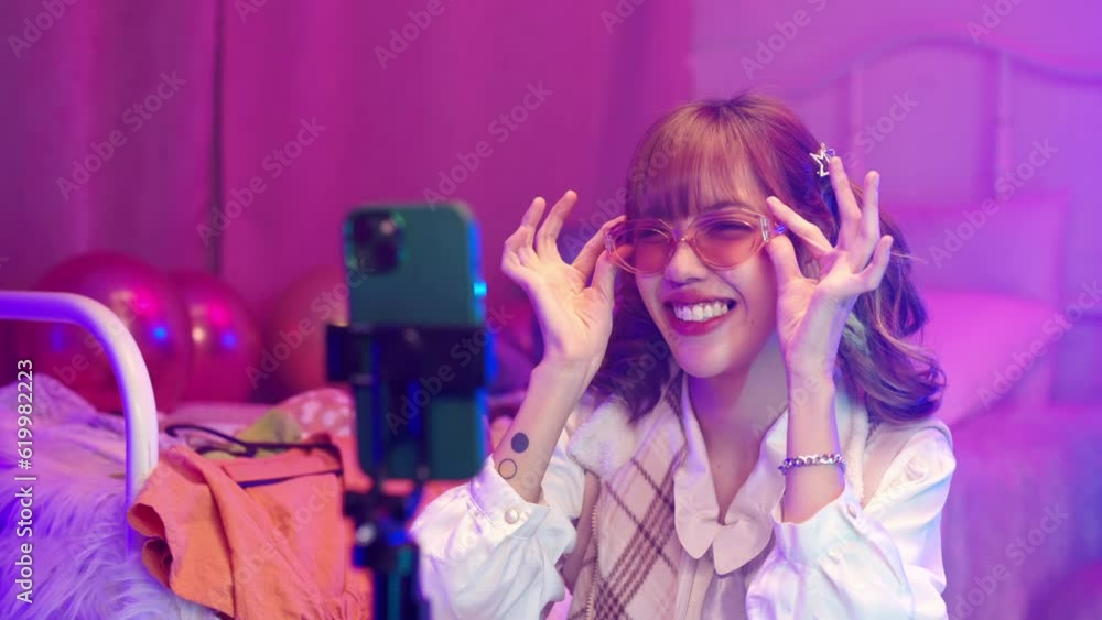 Young Asian generation z woman vlogger influencer using smartphone live streaming presentation ...